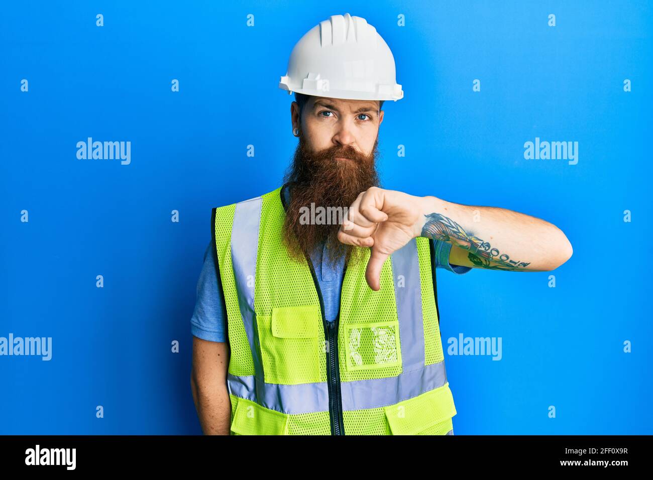 Redhead man with long beard wearing safety helmet and reflective jacket ...