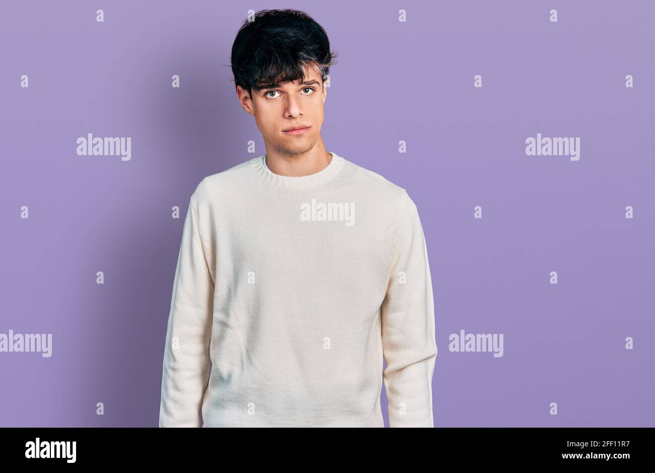 Handsome hipster young man wearing casual winter sweater depressed and ...