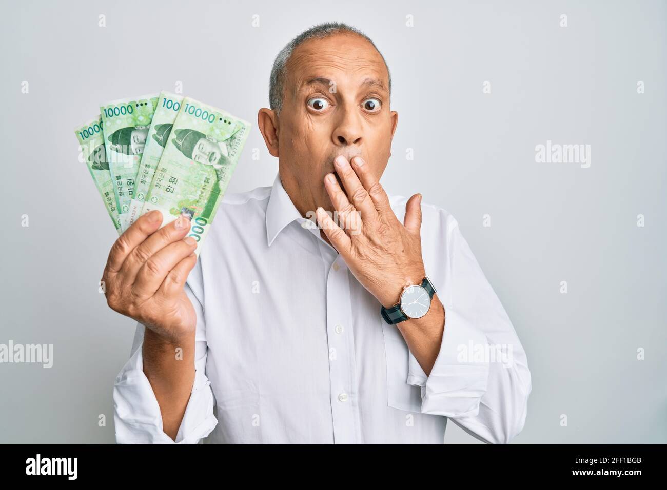 Handsome senior man holding 10000 south korean won banknotes covering ...