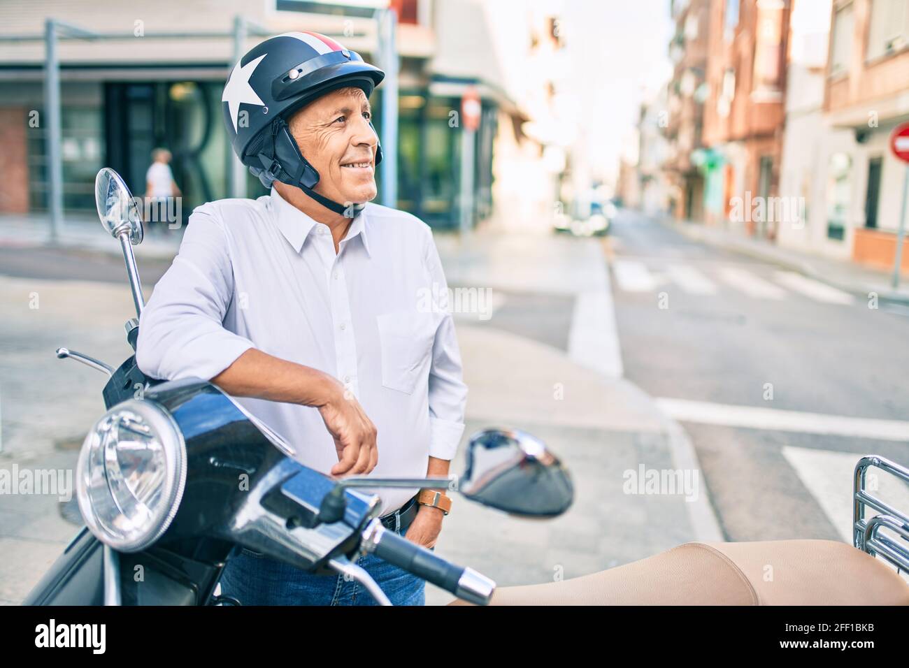 Senior motorcyclist man smiling happy wearing moto helmet at the city ...