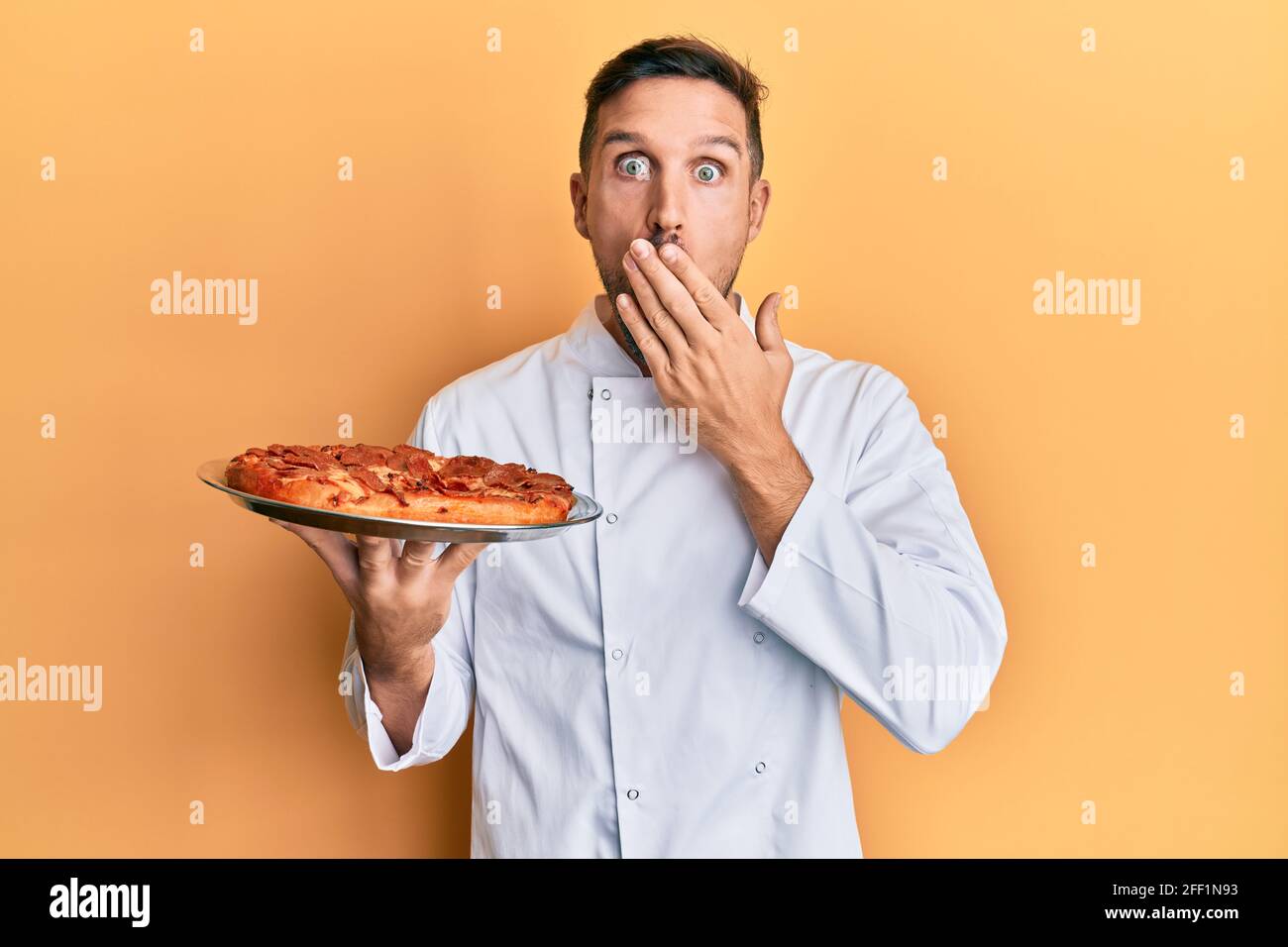 Handsome man with beard professional cook holding italian pizza ...