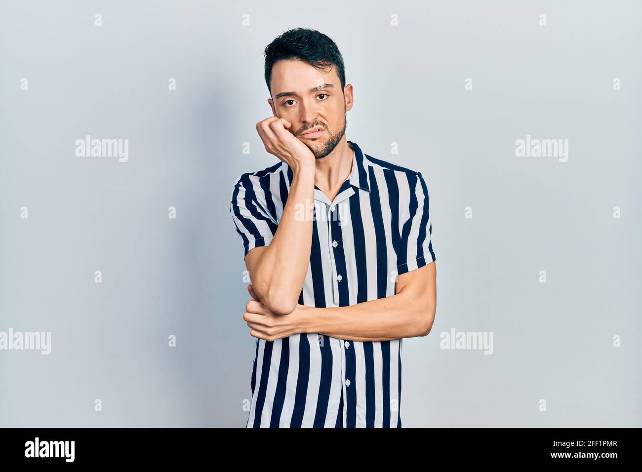 Young hispanic man wearing casual clothes thinking looking tired and ...