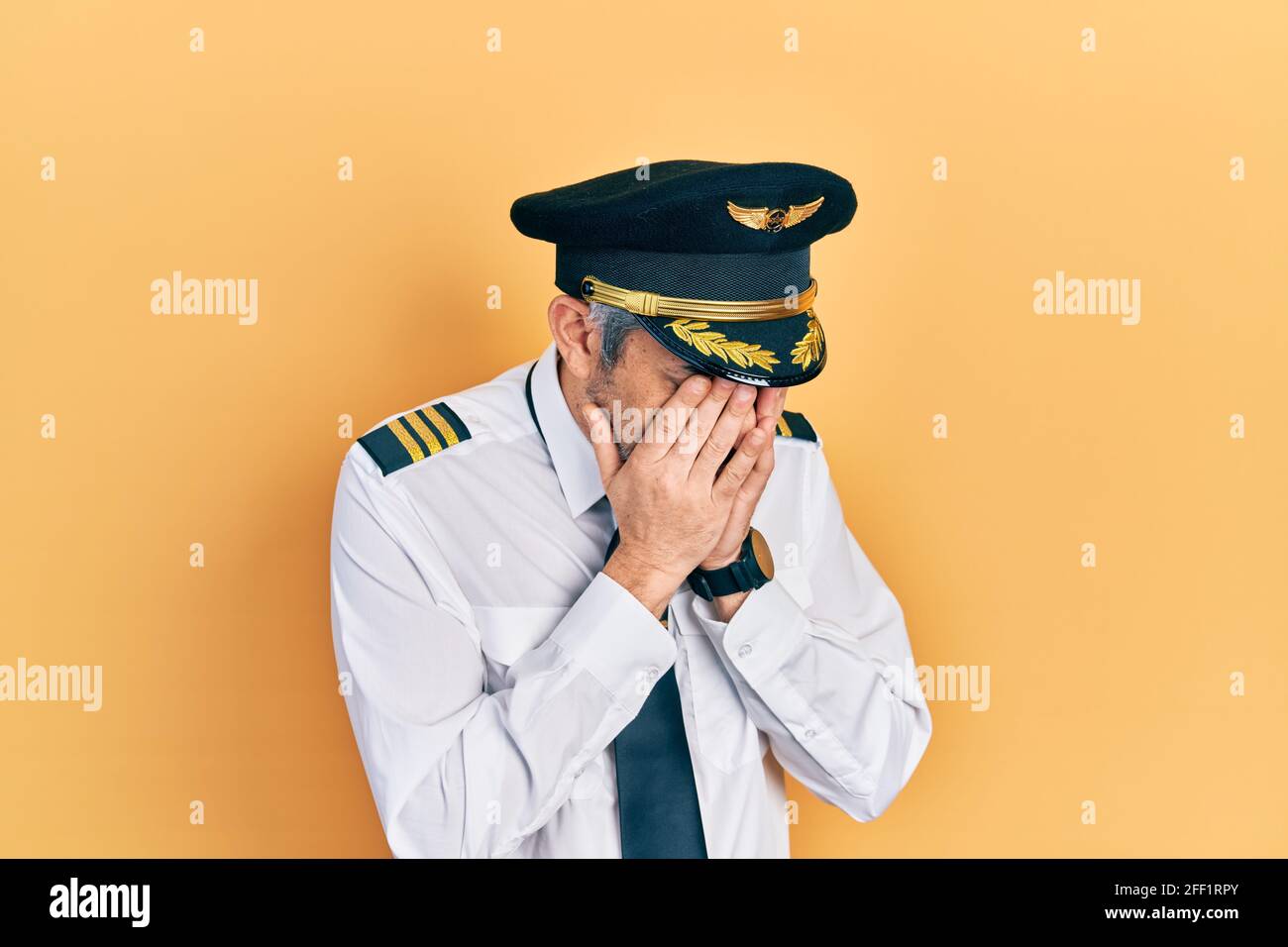 Handsome middle age man with grey hair wearing airplane pilot uniform ...