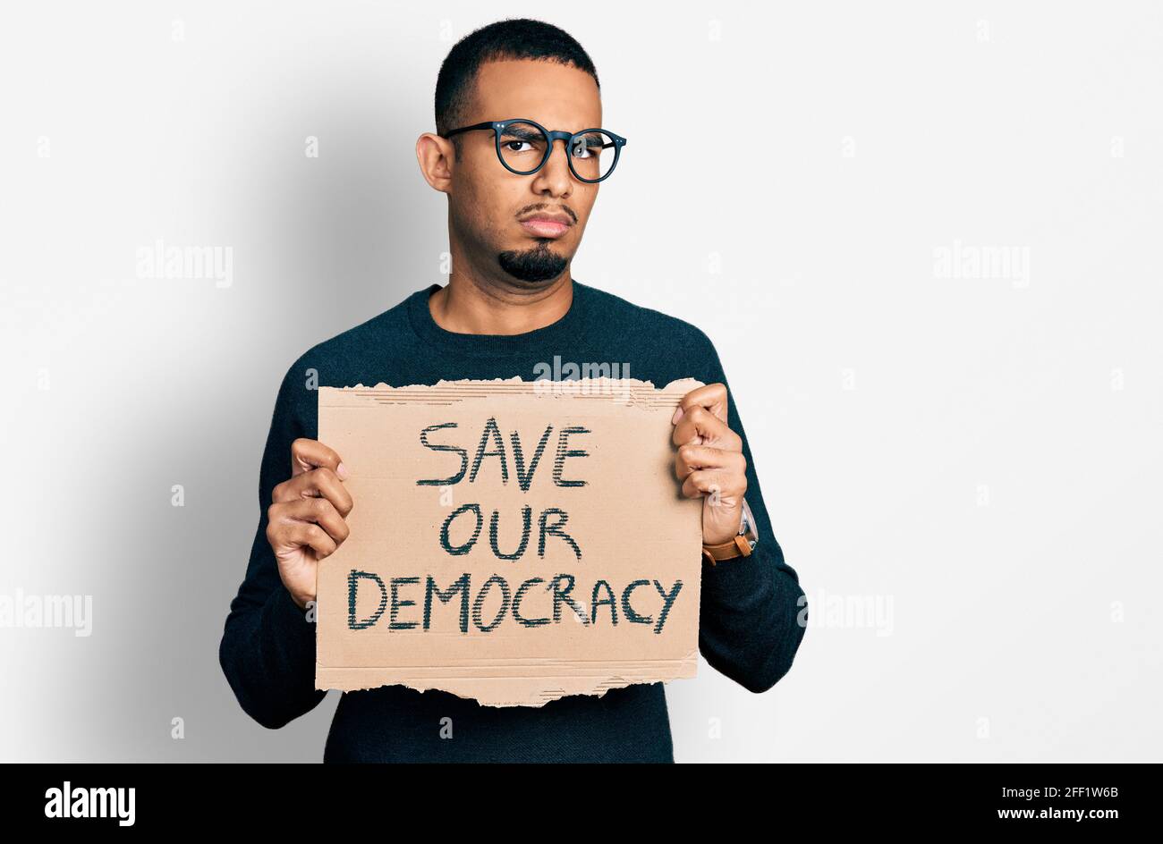 Young african american man holding save our democracy protest banner in ...