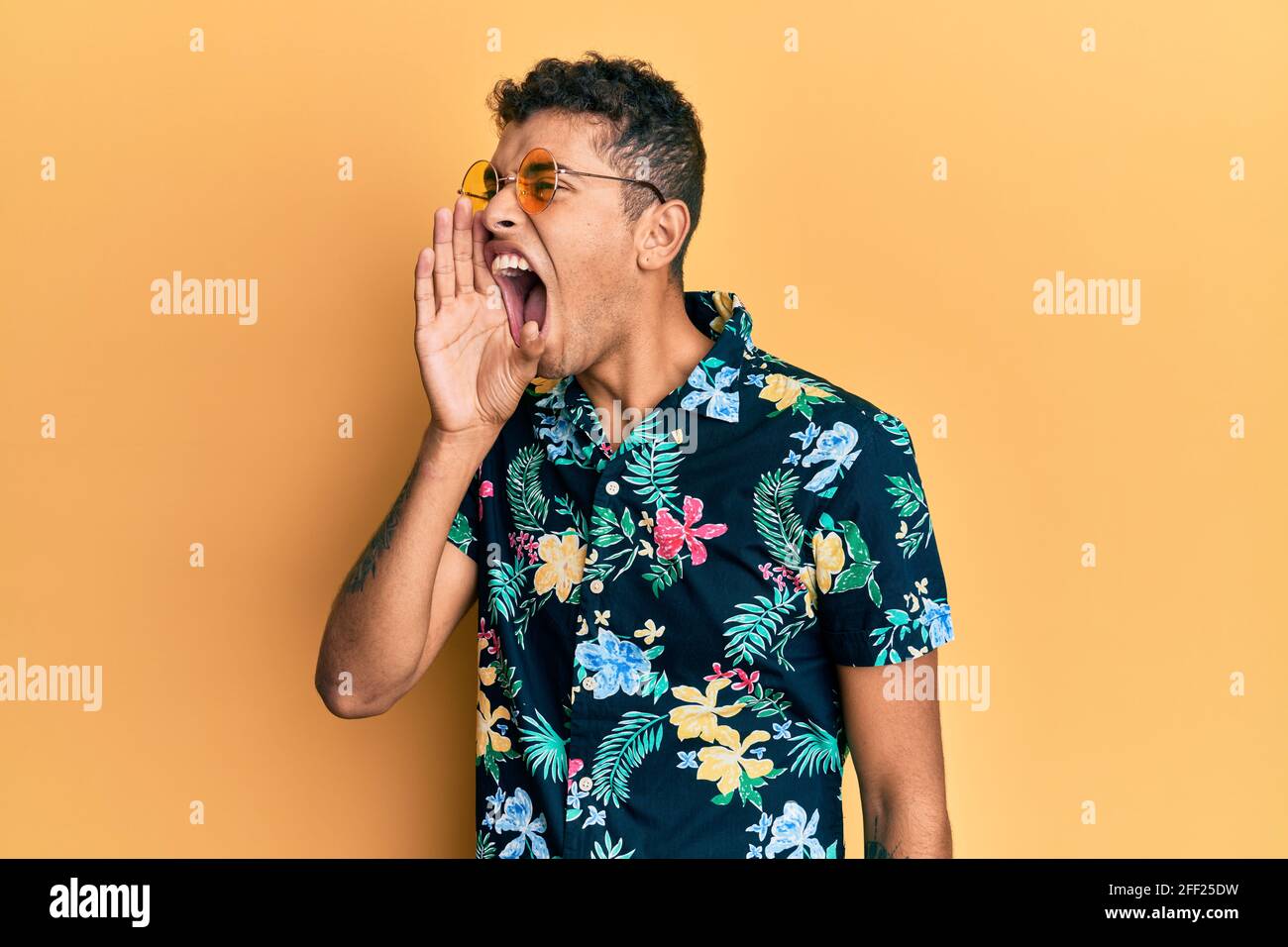 Young handsome african american man wearing summer style shouting and ...
