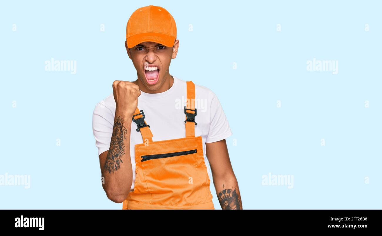 Young handsome african american man wearing handyman uniform angry and ...
