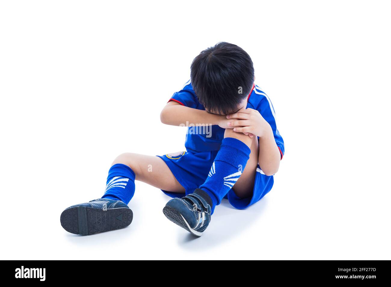 Sports injury. Youth asian (thai) soccer player in blue uniform with ...