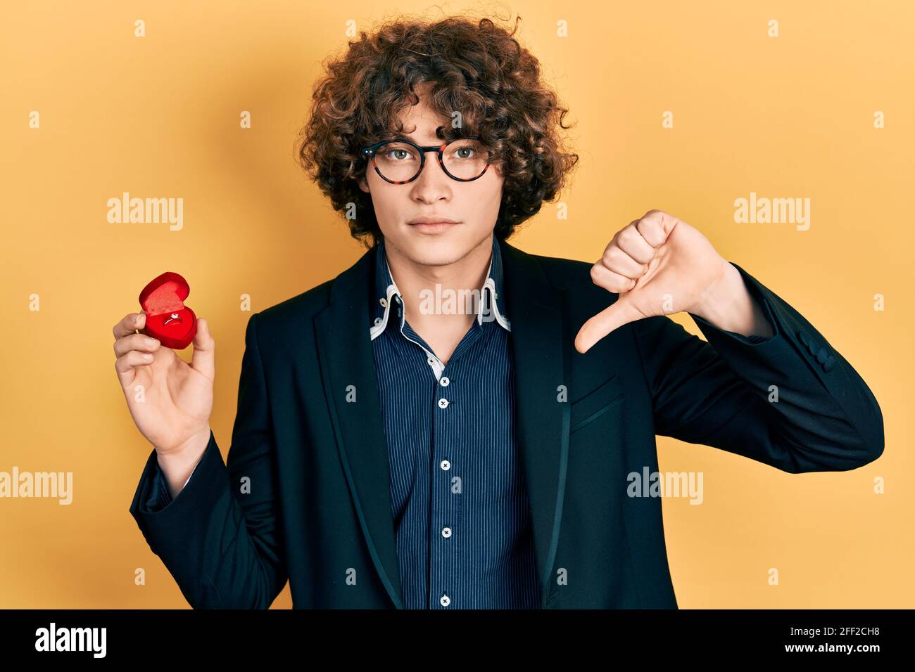 Handsome young man holding engagement ring for proposal with angry face ...