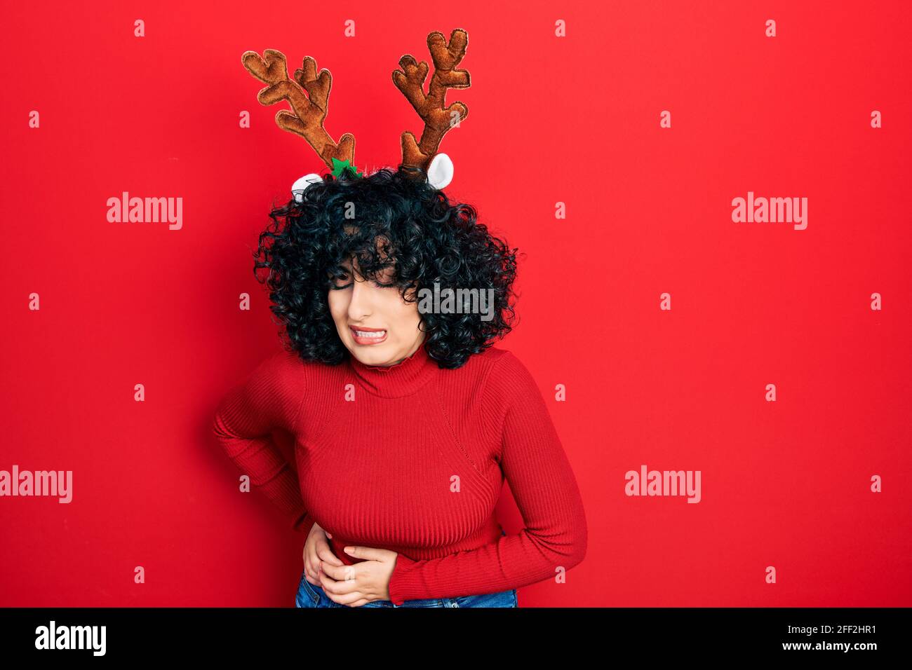 Young middle east woman wearing cute christmas reindeer horns with hand ...