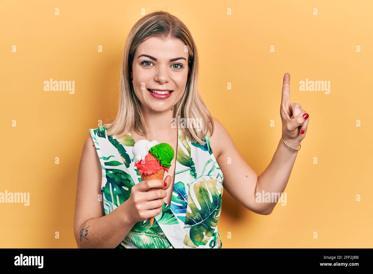 Beautiful caucasian woman eating ice cream smiling with an idea or ...