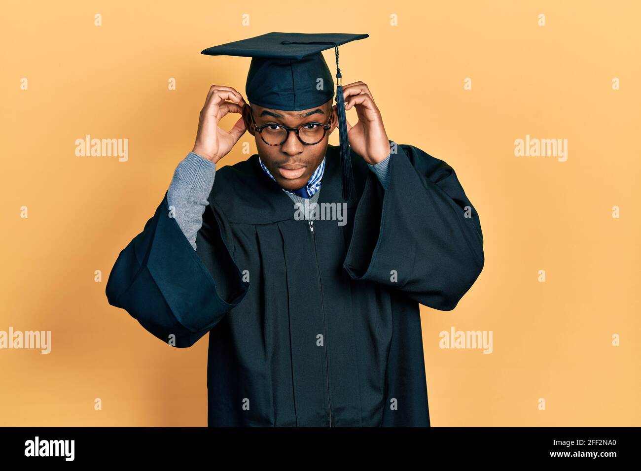 Young african american man wearing graduation cap and ceremony robe ...