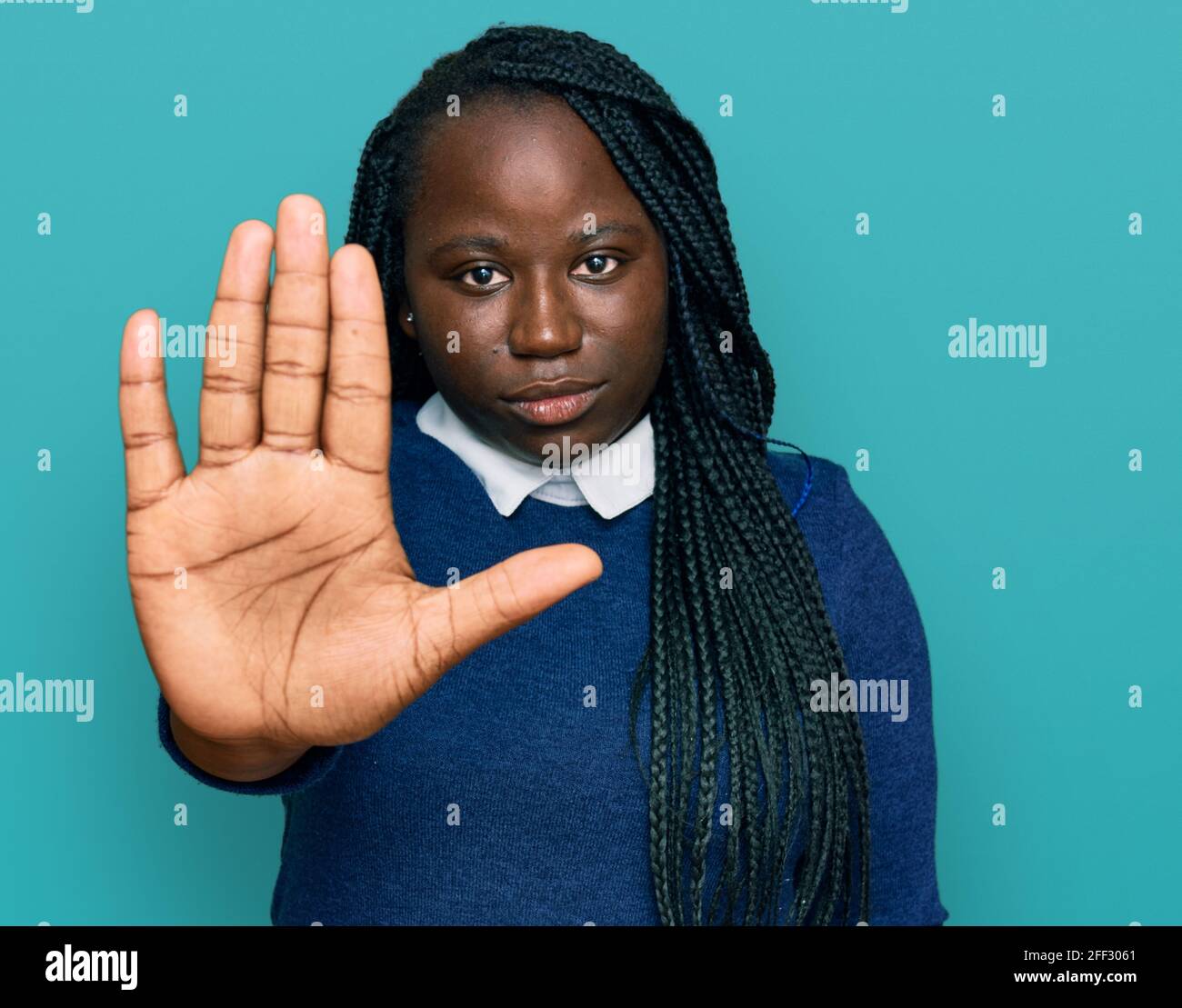 Young black woman with braids wearing casual clothes doing stop sing ...