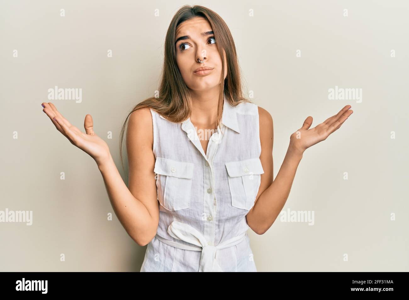 Young hispanic woman wearing casual clothes clueless and confused with ...
