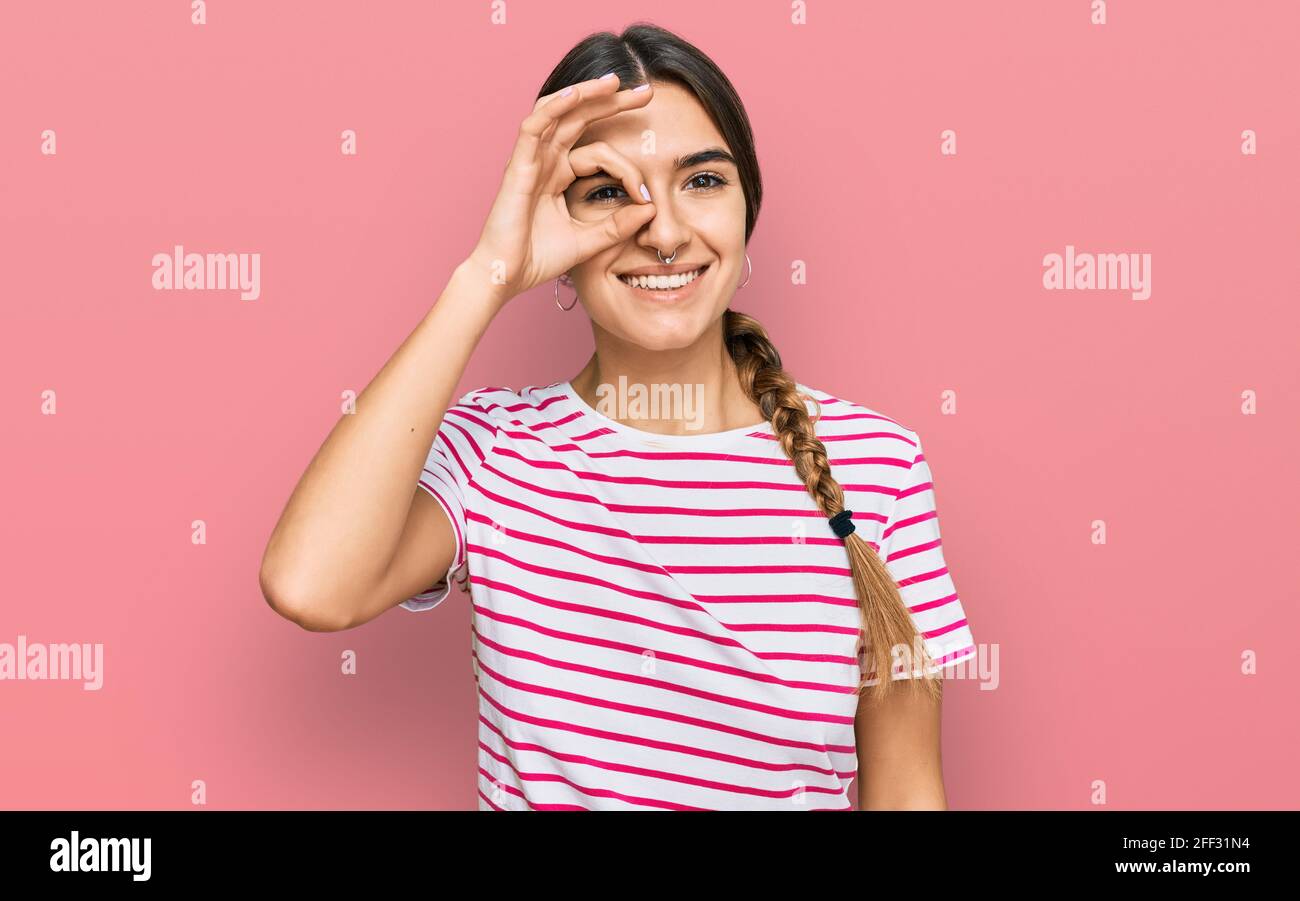 Young hispanic woman wearing casual clothes doing ok gesture with hand ...