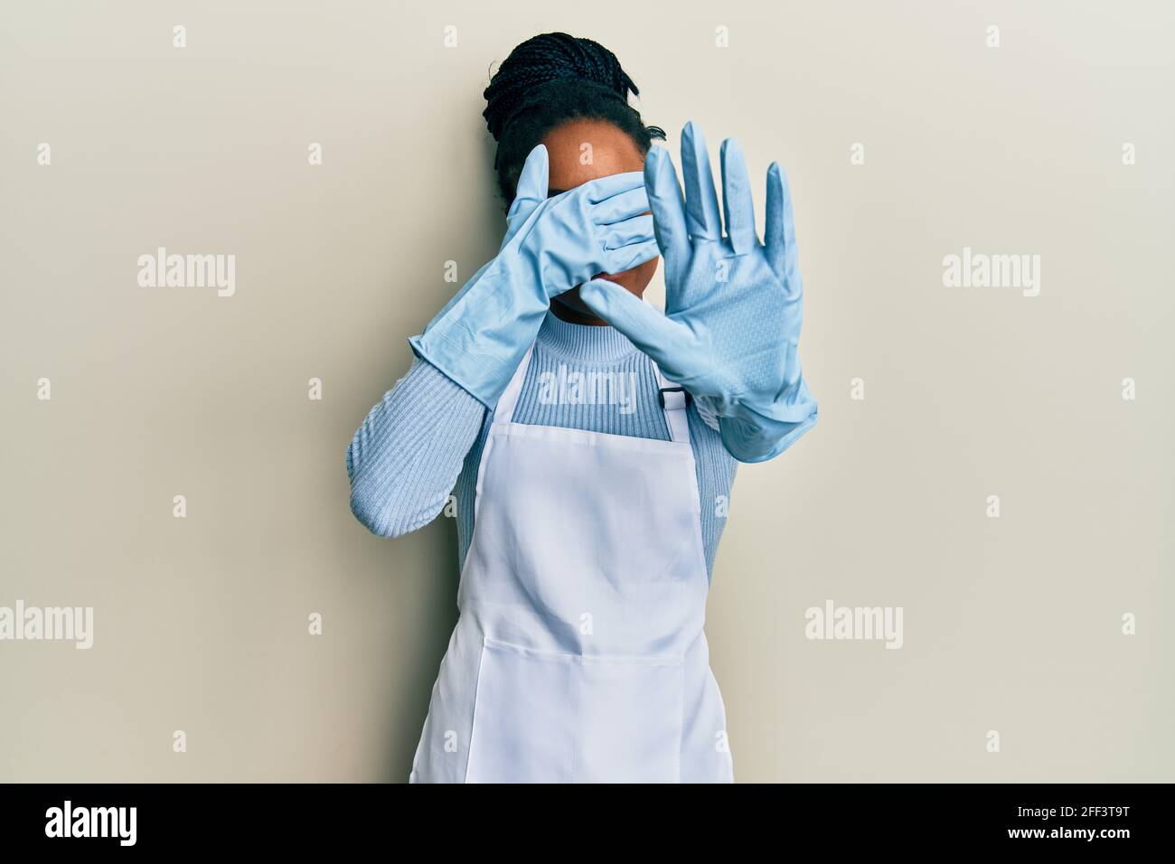 African american woman with braided hair wearing cleaner apron and ...