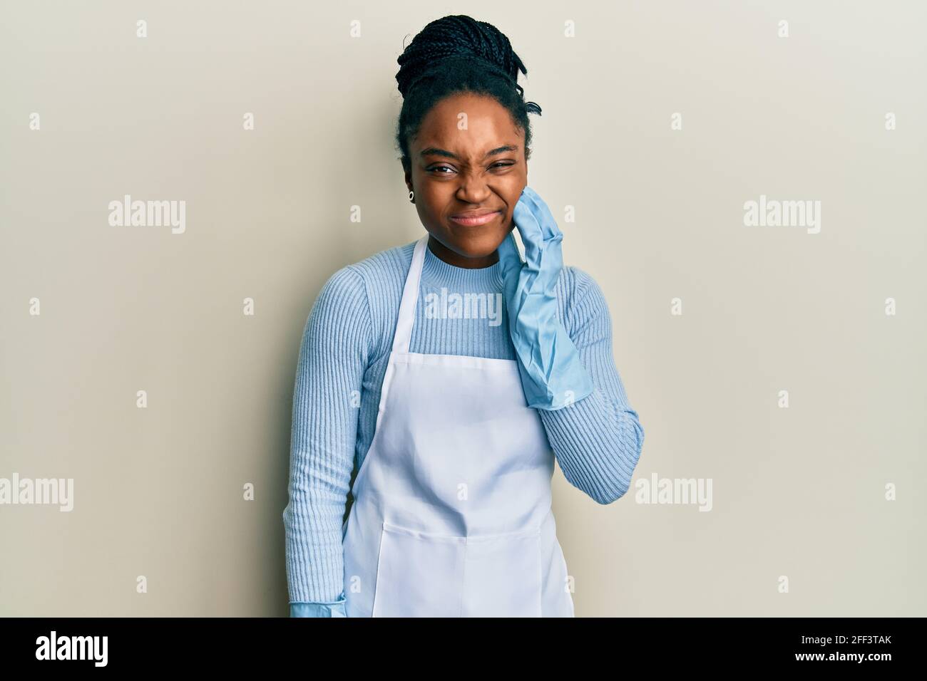 African american woman with braided hair wearing cleaner apron and ...