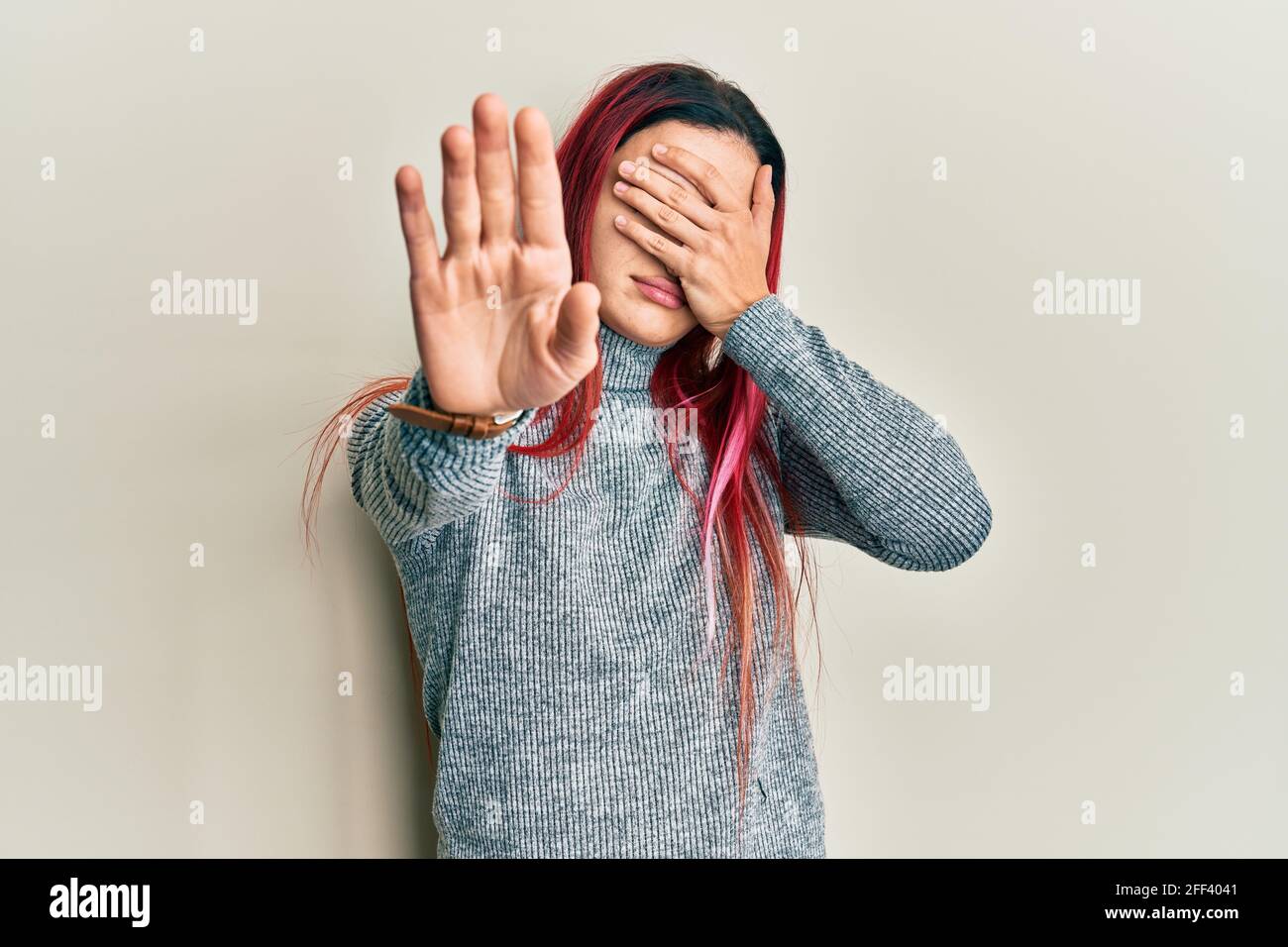 Young caucasian woman wearing casual clothes covering eyes with hands ...