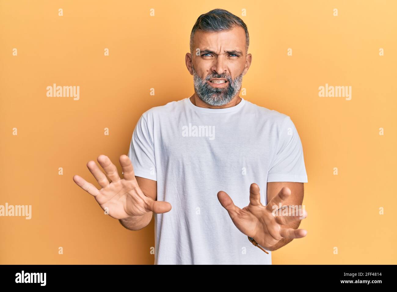 Middle age handsome man wearing casual white tshirt disgusted ...