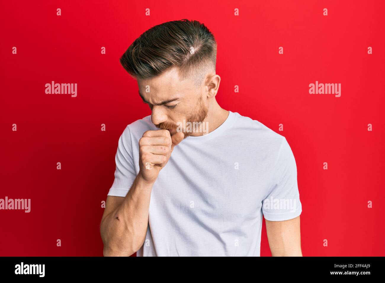 Young redhead man wearing casual white t shirt feeling unwell and ...