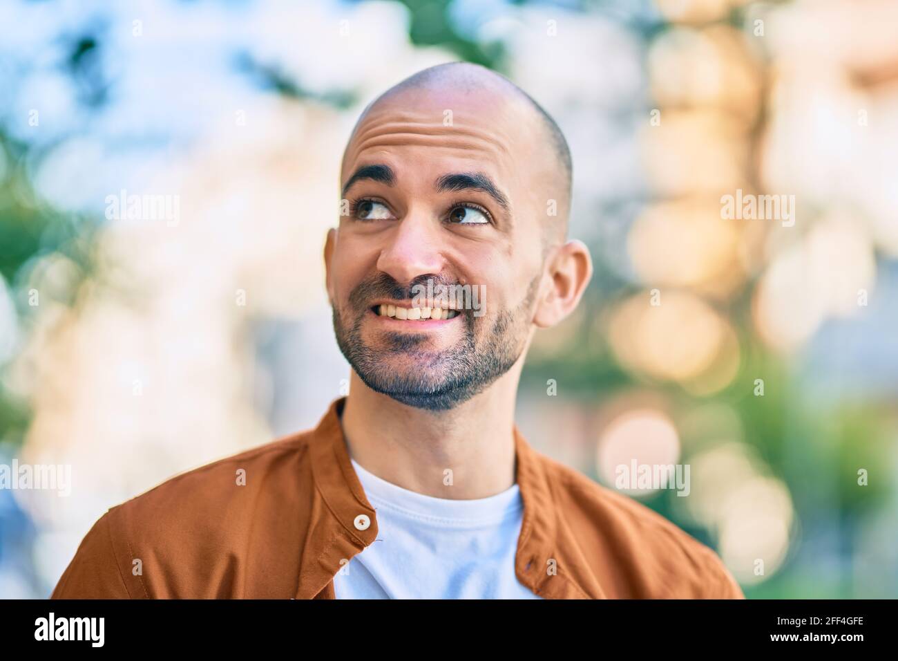 Young hispanic bald man smiling happy standing at the city Stock Photo ...
