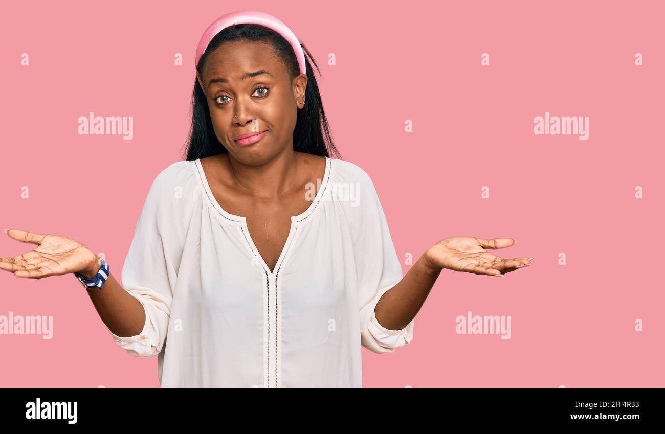 Young black woman wearing casual clothes clueless and confused ...