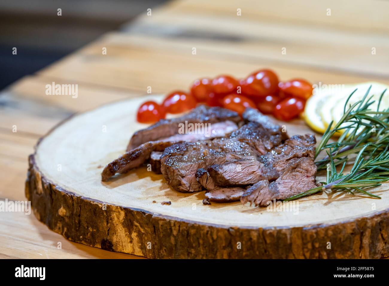 Steak Slice on the wood plate, Decoration by Lemon slice, tomato, and ...
