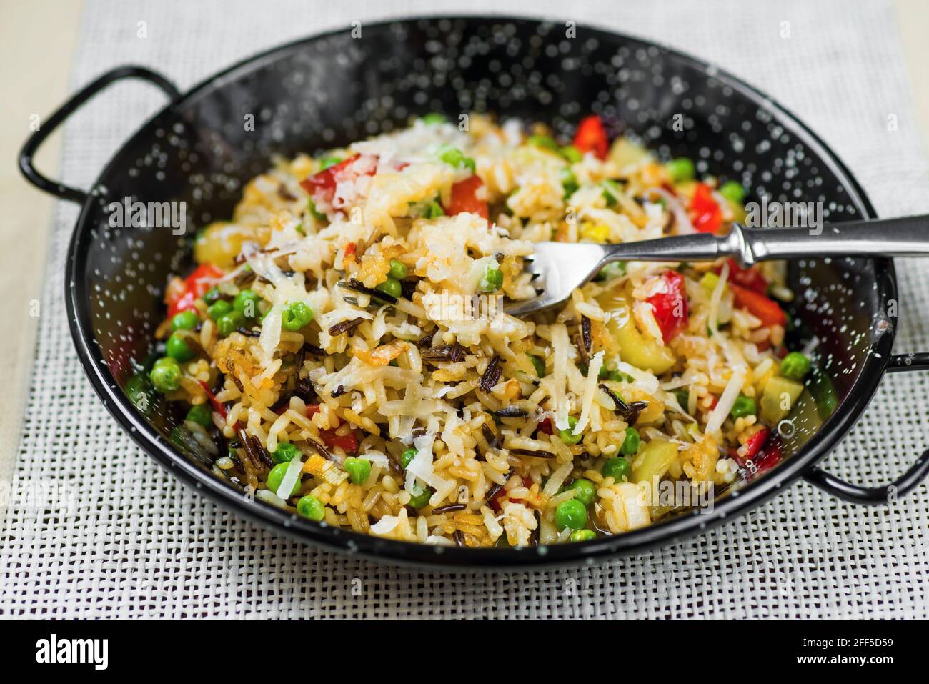 Risotto from indian rice with vegetable (pepper, pea) sprinkled with ...
