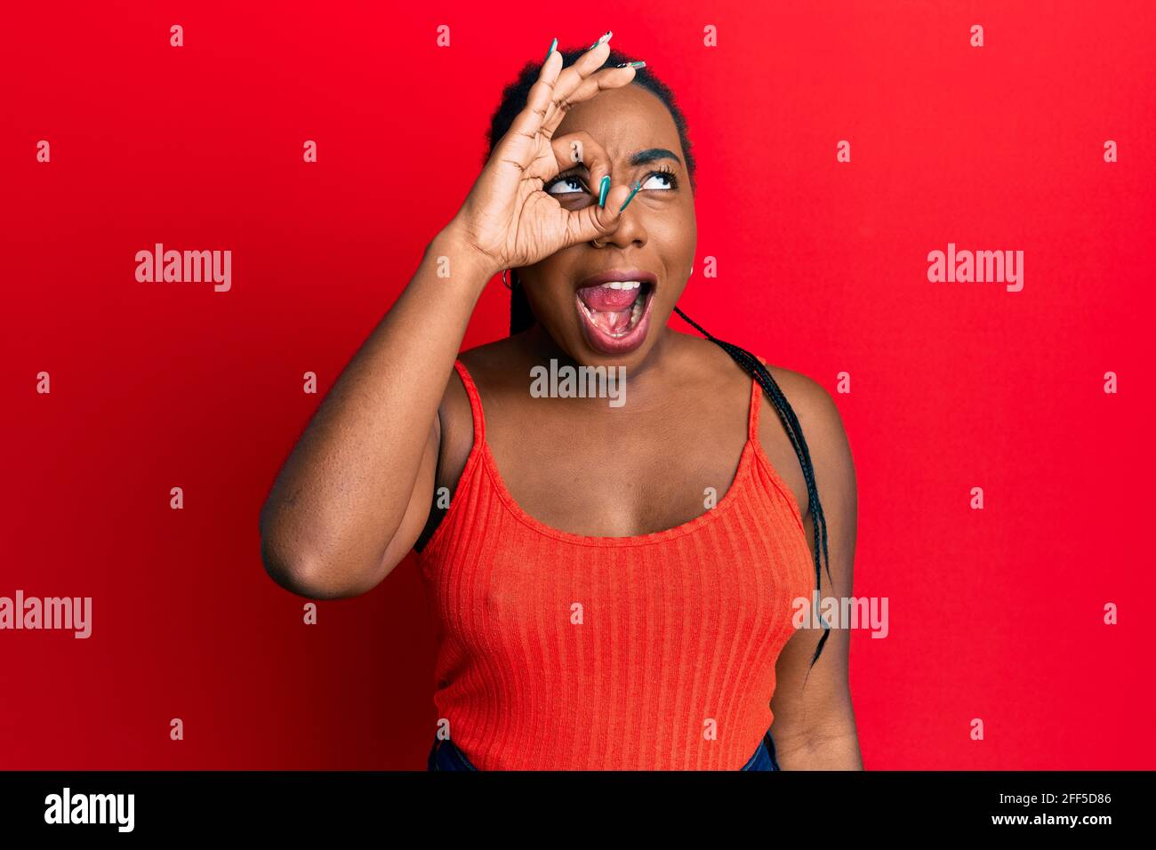 Young african american woman doing ok sign on eye angry and mad ...