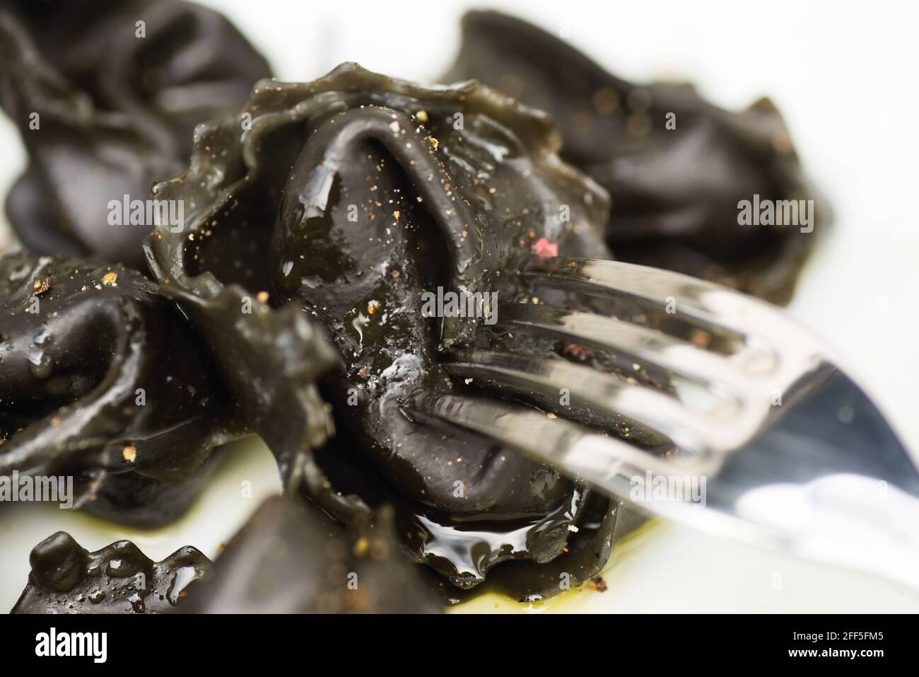 Black agnolotti stuffed with meat,a type of pasta typical of the ...
