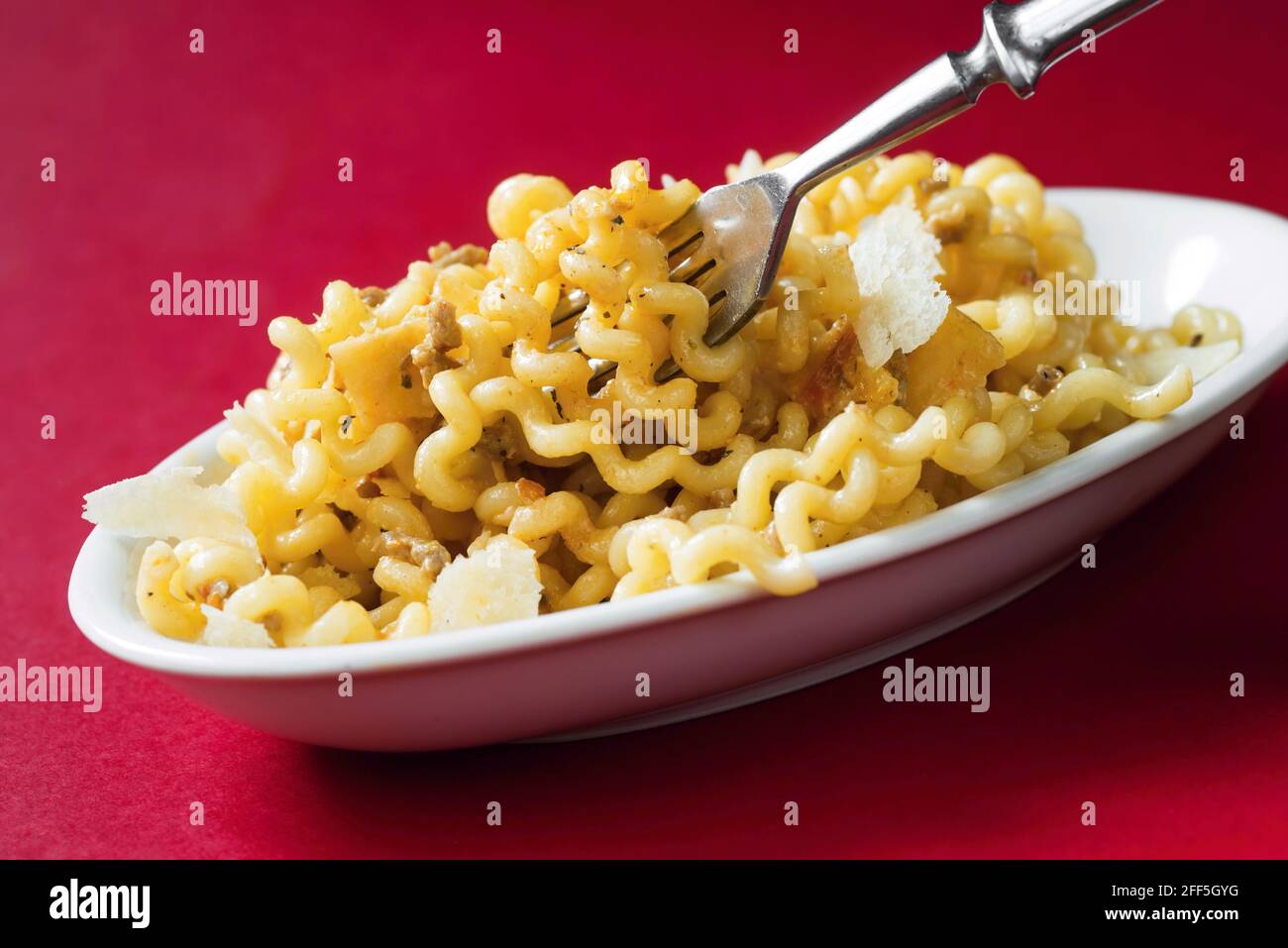 Italian pasta in spiral shape, fusilli col buco, on white plate with ...