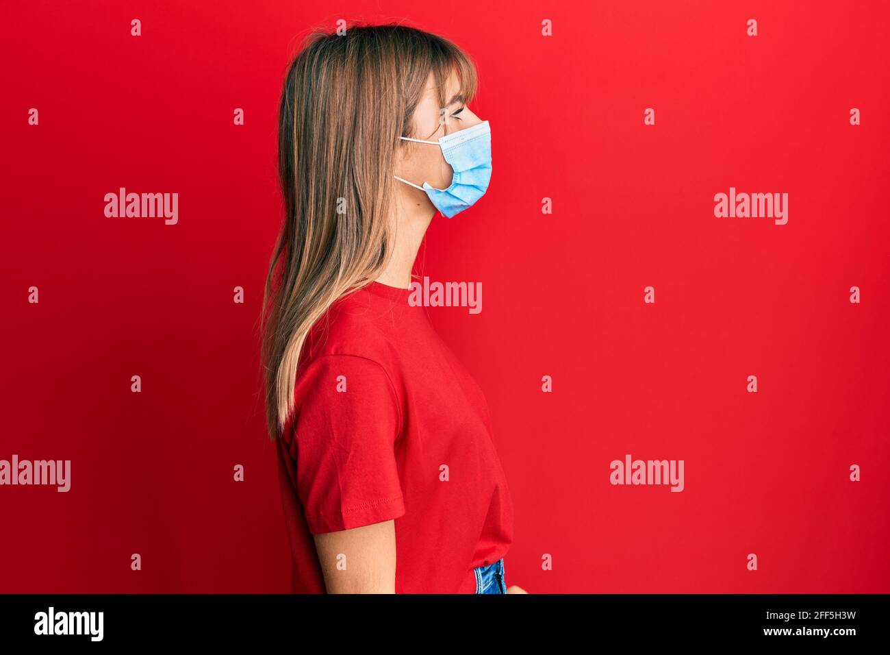 Teenager caucasian girl wearing medical mask looking to side, relax ...