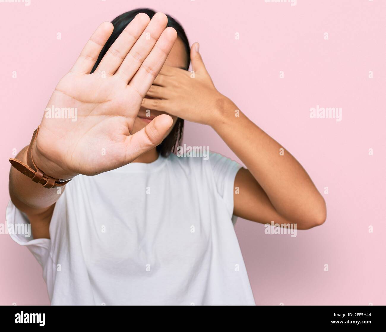 Young asian woman wearing casual white t shirt covering eyes with hands ...