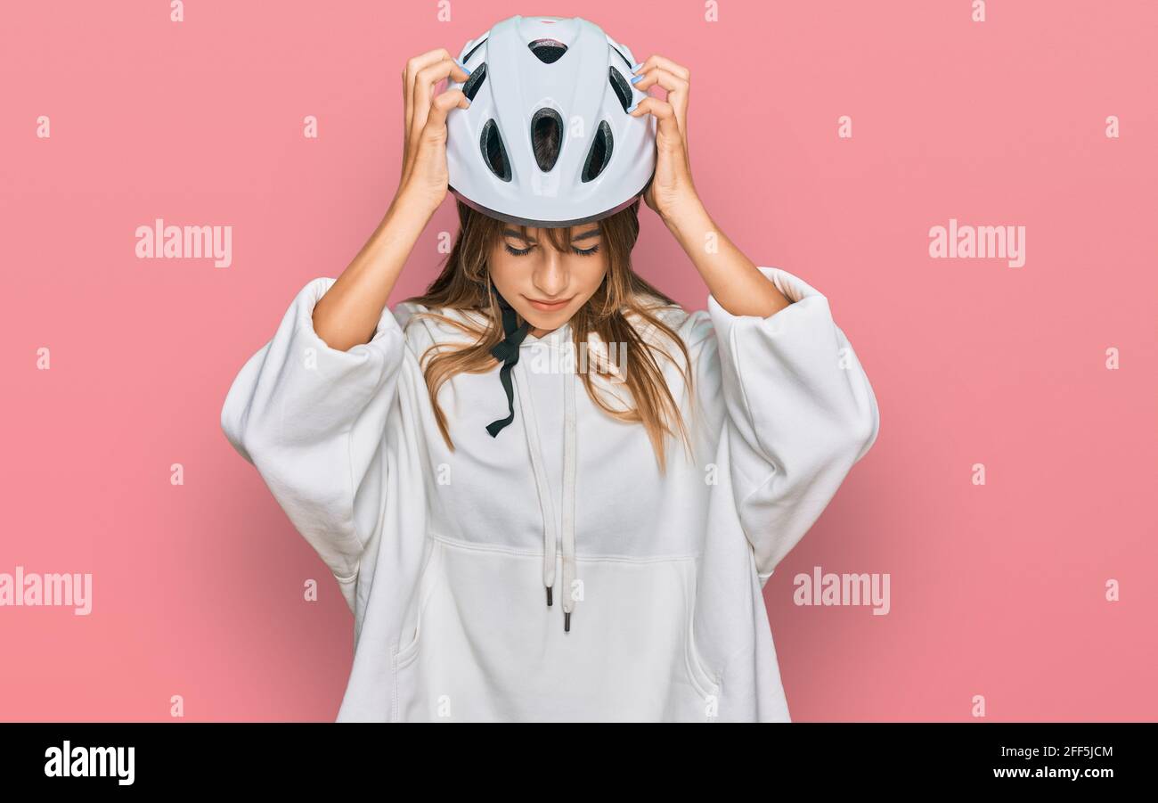 Teenager caucasian girl wearing bike helmet suffering from headache ...