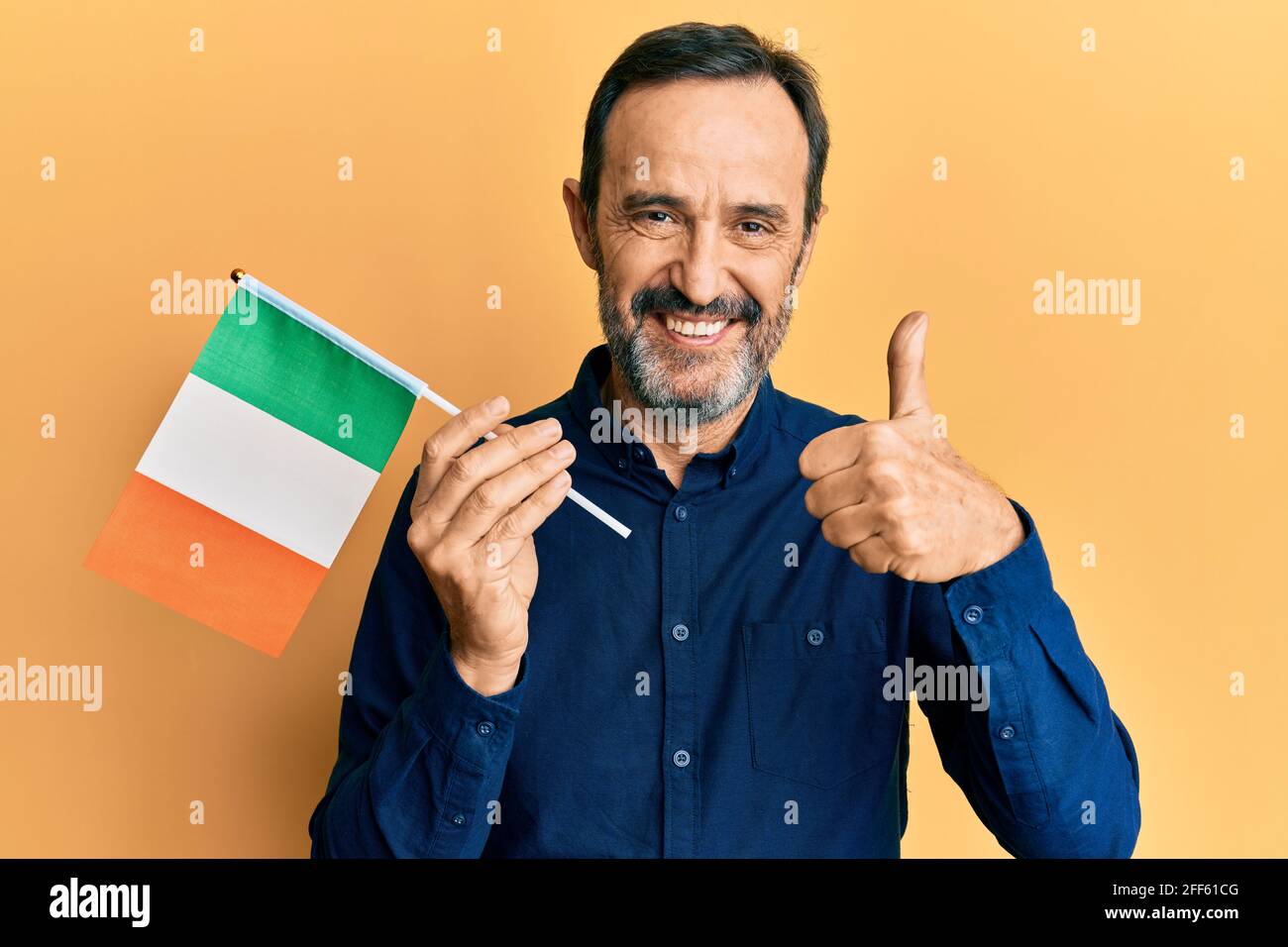 Middle age hispanic man holding ireland flag smiling happy and positive ...