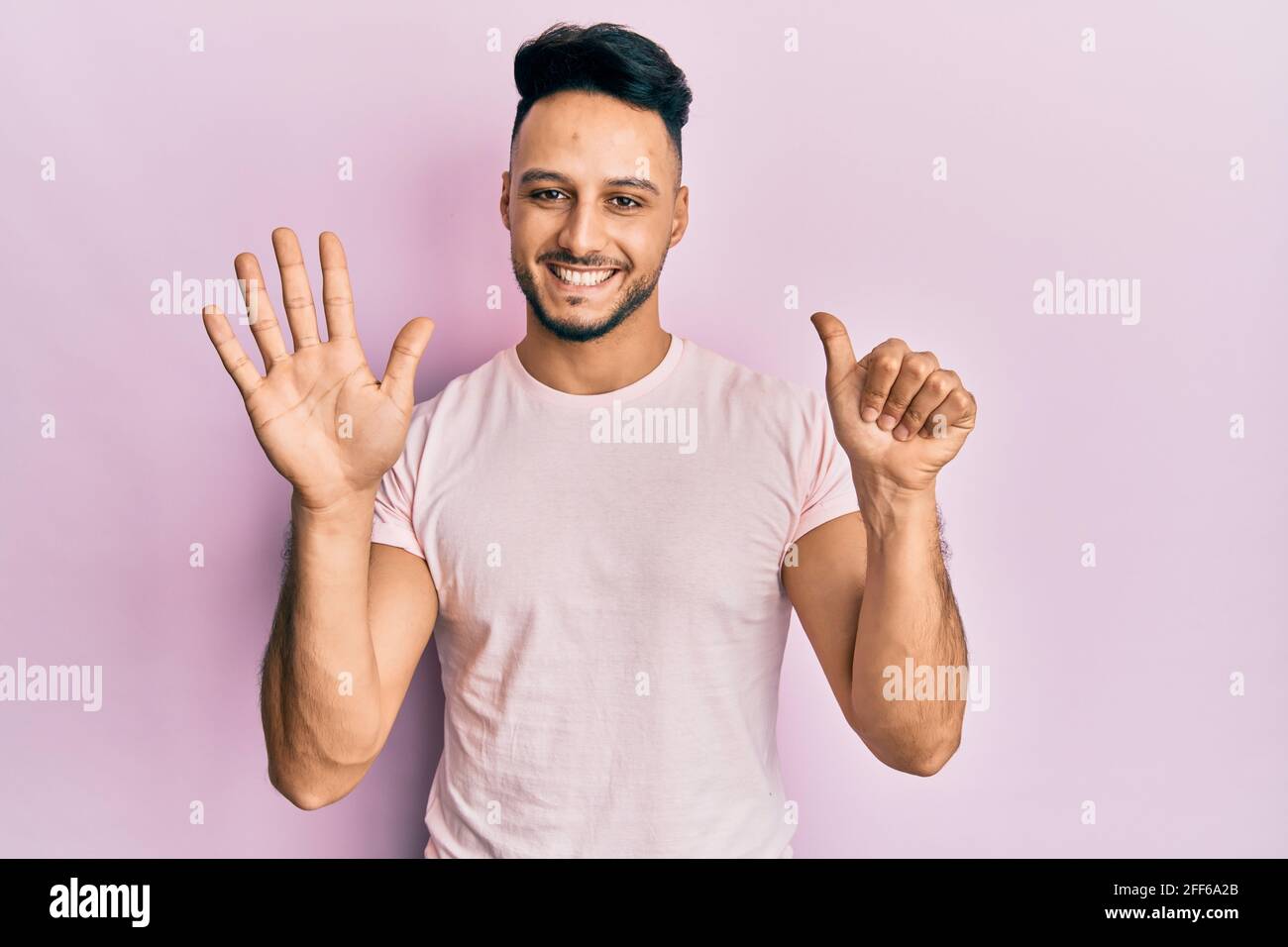 Young arab man wearing casual clothes showing and pointing up with ...