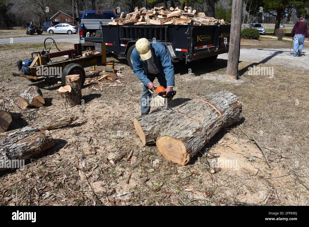 A man cutting up a log for firewood Stock Photo - Alamy