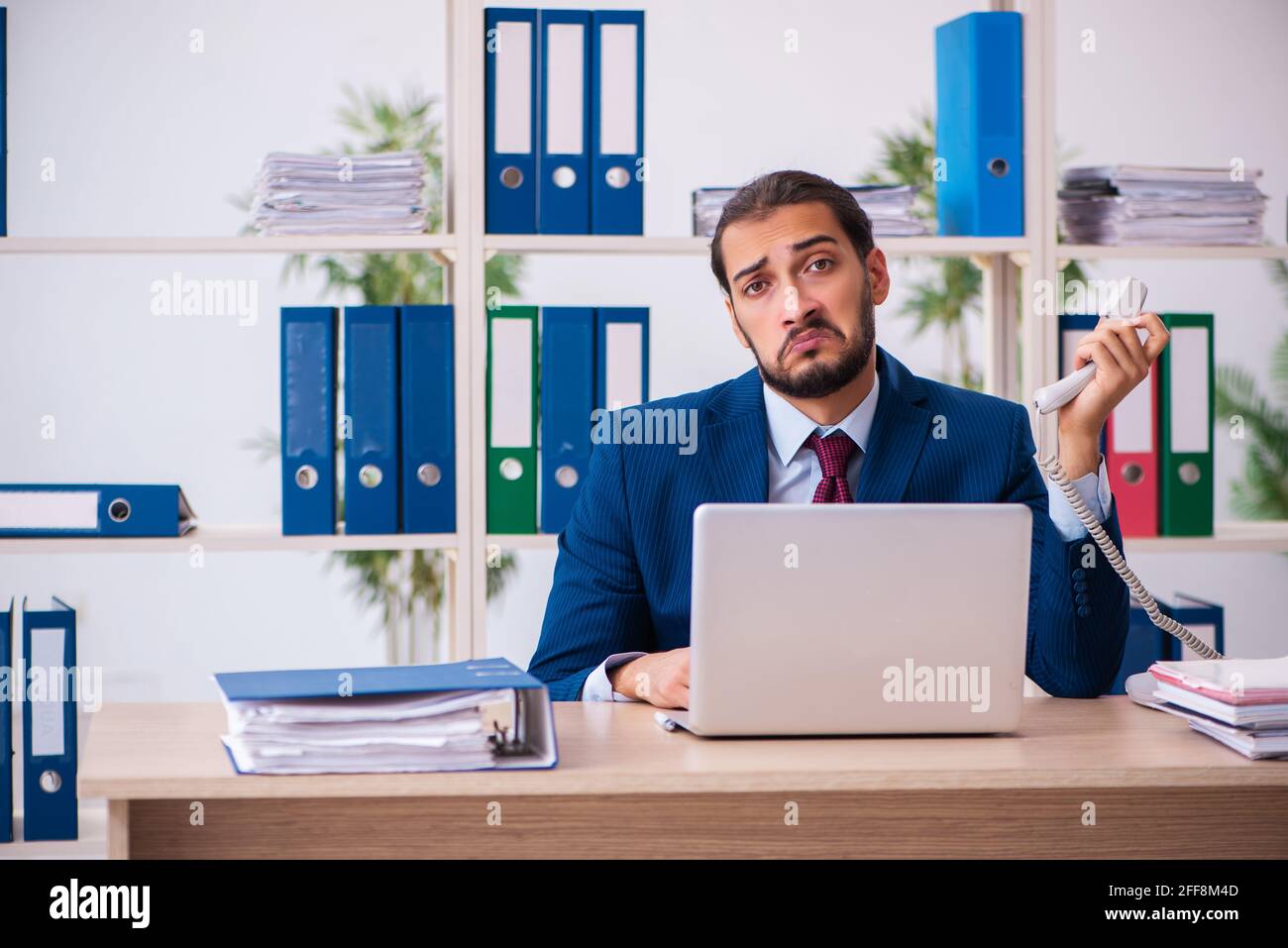 Young employee and too many work in the office Stock Photo - Alamy
