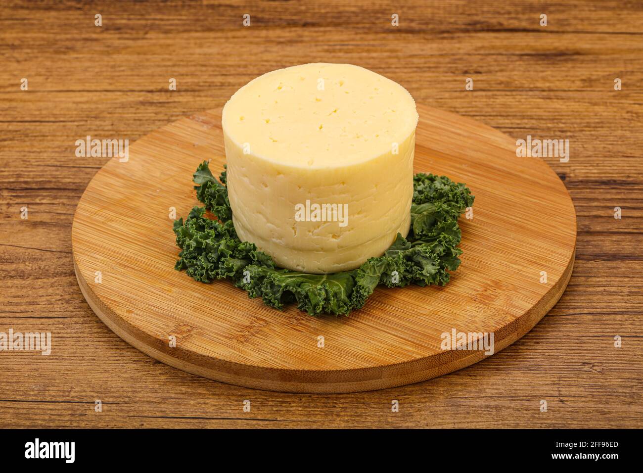 Yellow round dairy soft cheese piece Stock Photo - Alamy