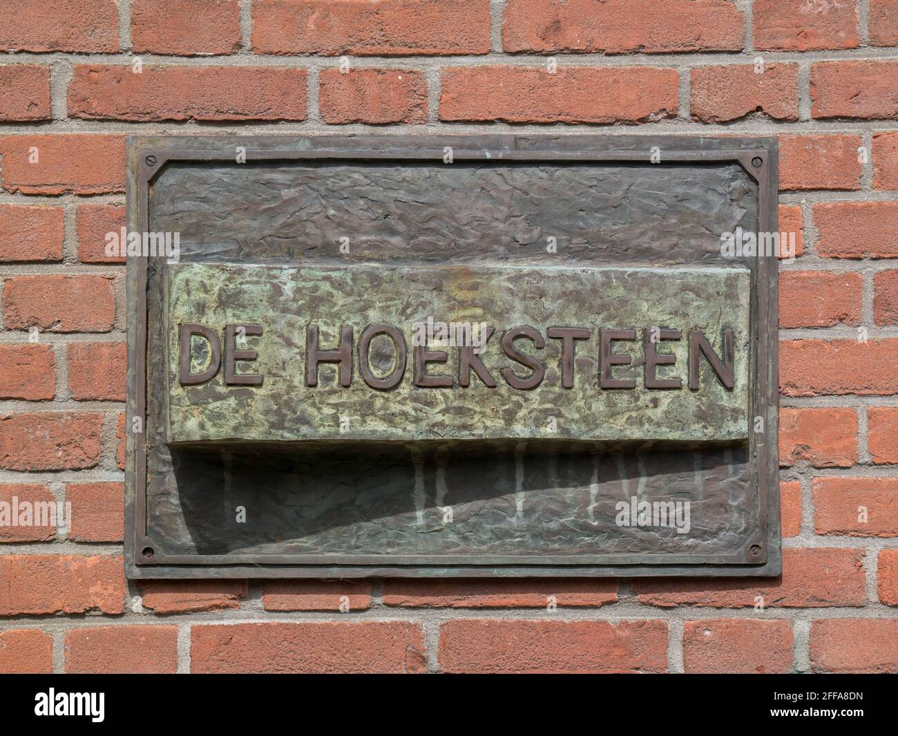 Stone relief with the text De Hoeksteen (cornerstone) on the wall of ...
