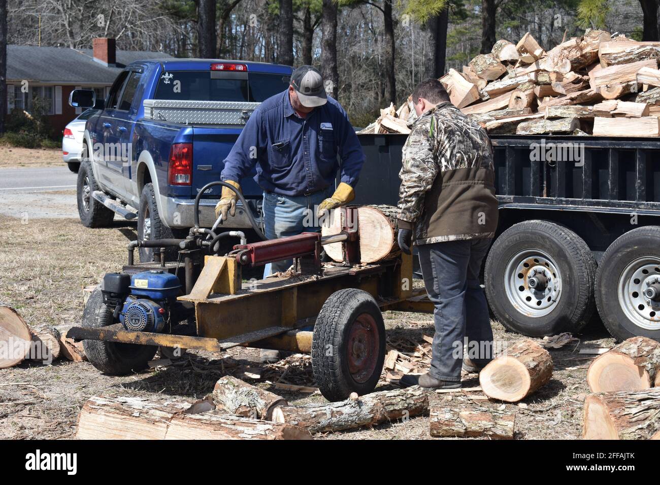 Men splitting logs for firewood Stock Photo - Alamy