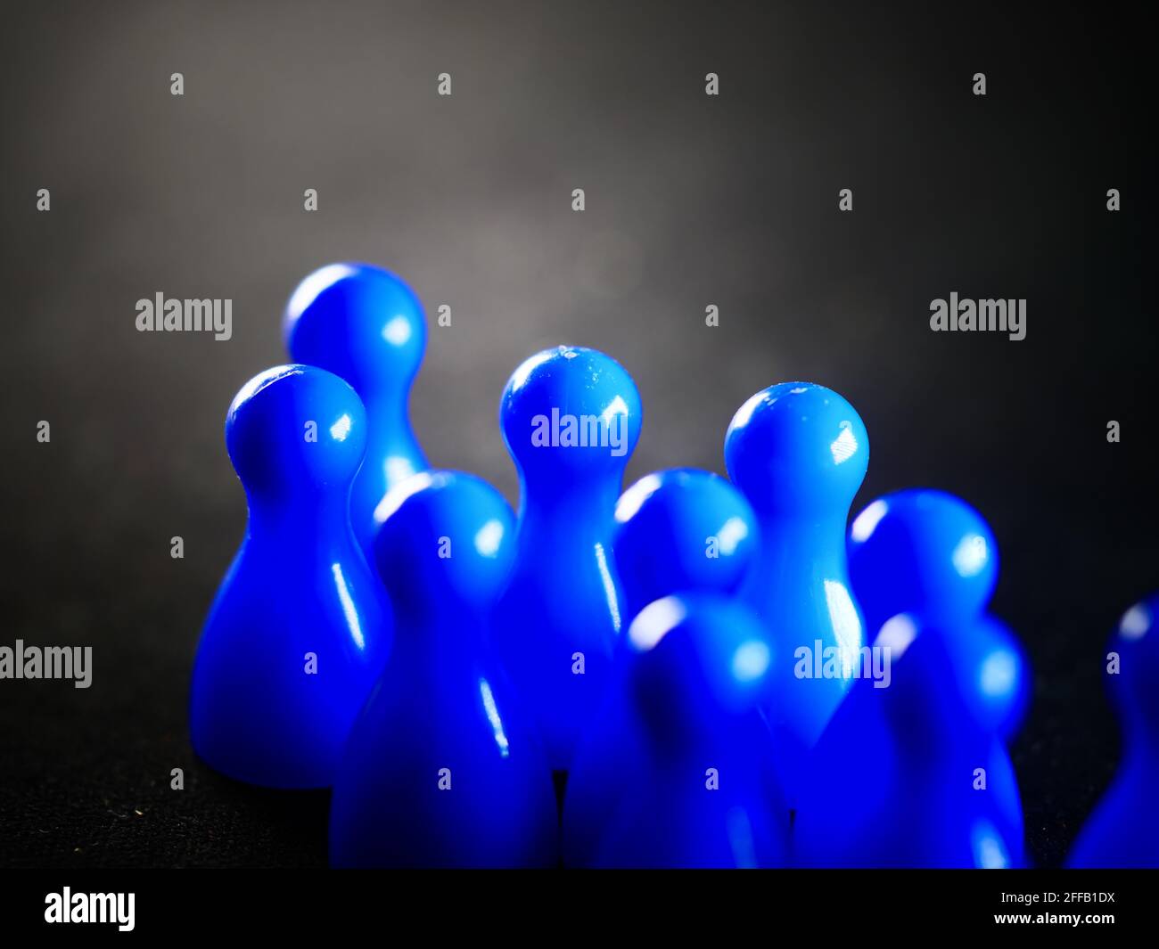 High angle shot of blue board game figures on a black surface Stock ...
