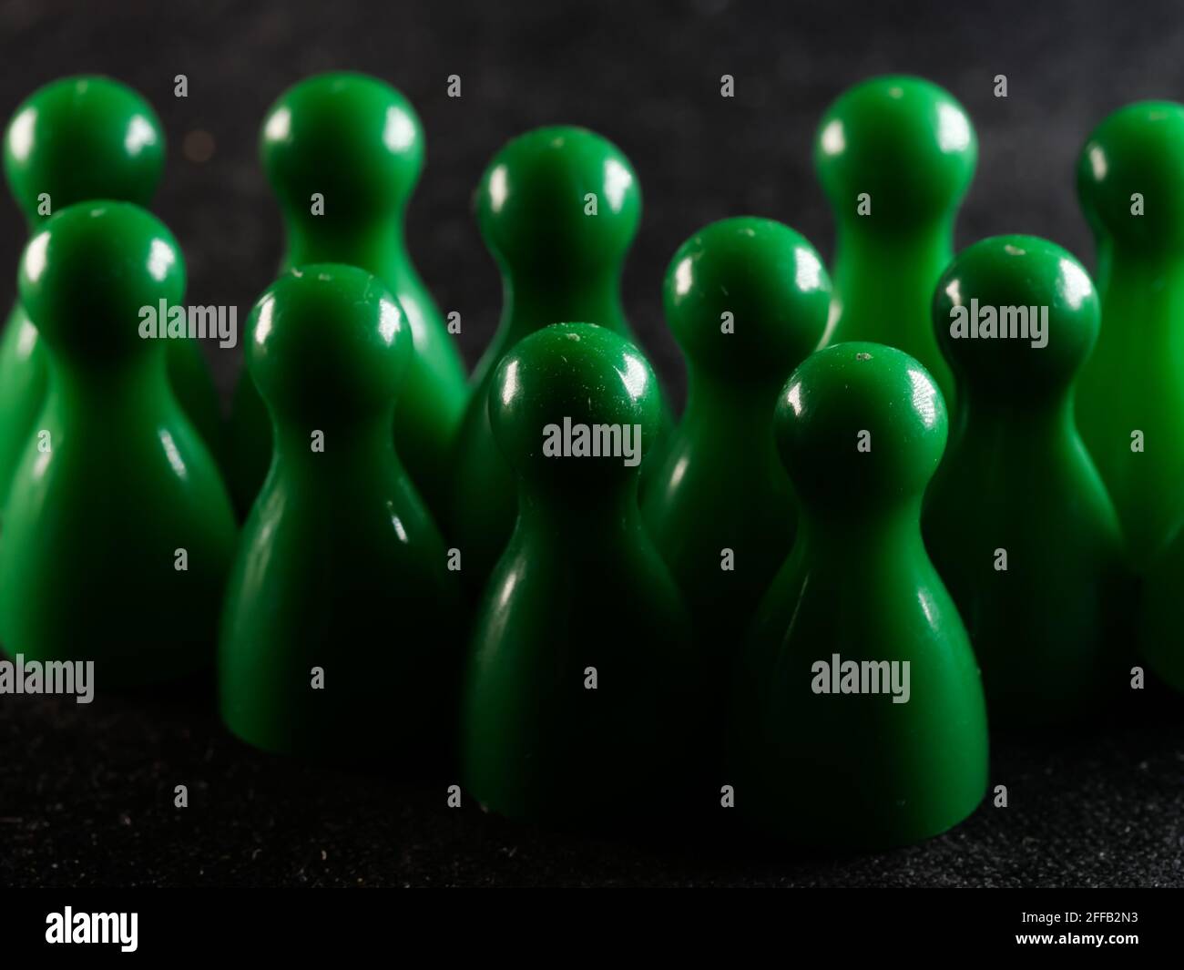 Closeup shot of green board game figures on a black surface Stock Photo ...