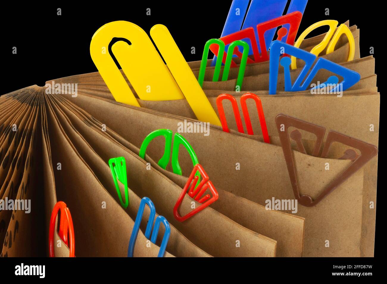 13 paperclips are attached to a paper tablet or book. The clips are ...