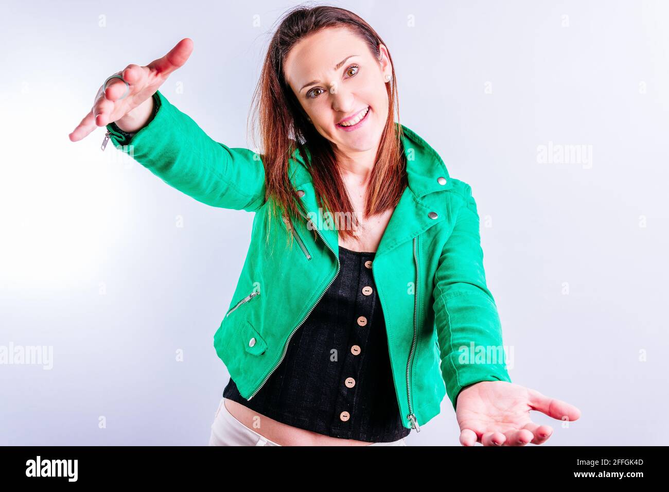 Beautiful young adult woman in green jacket showing offering a hug with ...