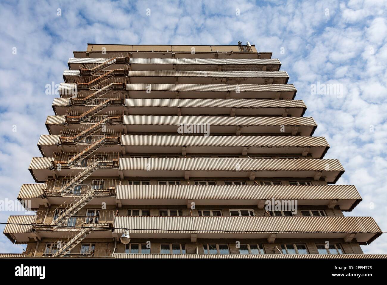Facade of an old multi-storey building with an iron staircase leading ...