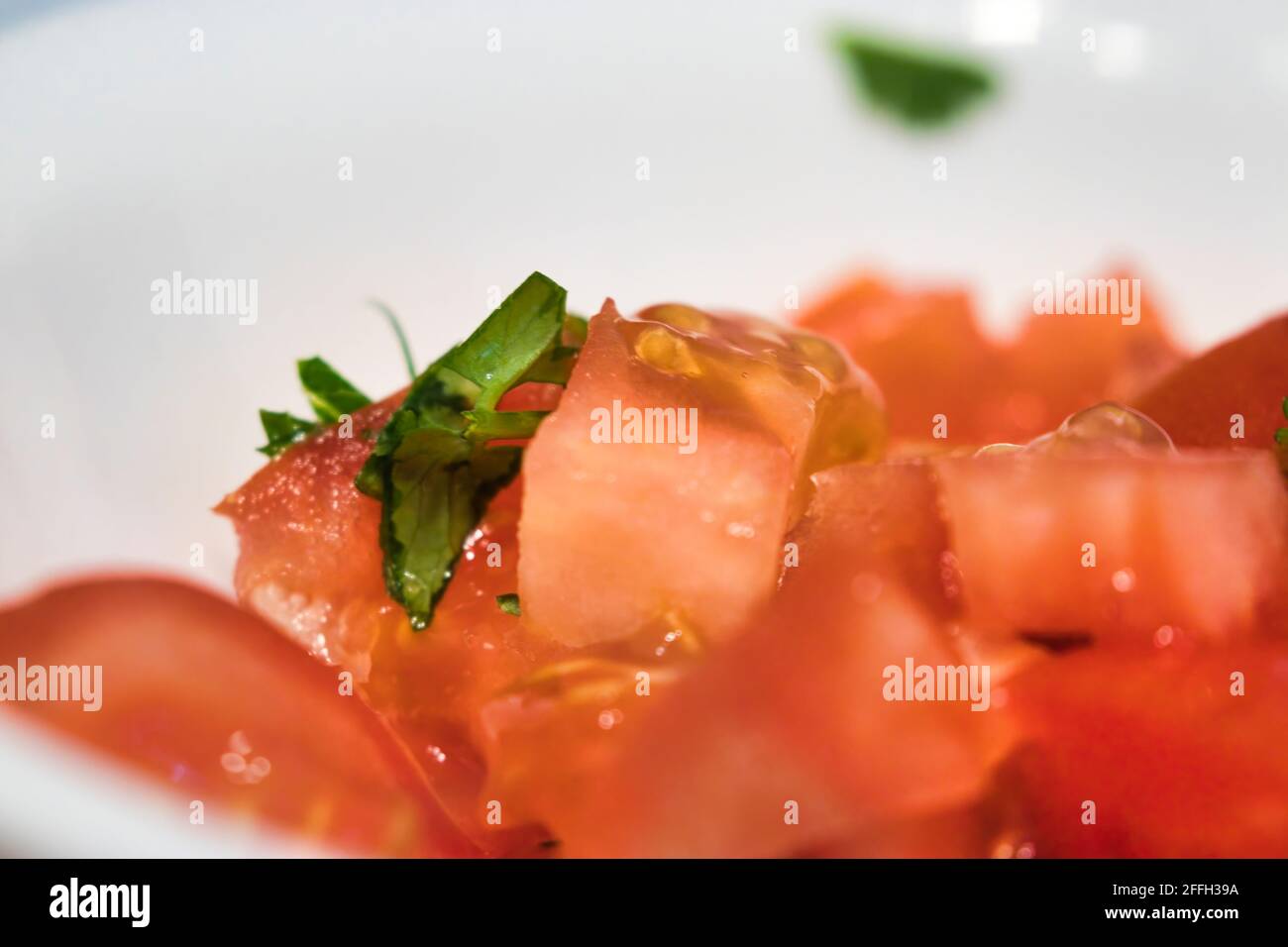 juicy tomato chunks with peices of chopped basil Stock Photo - Alamy