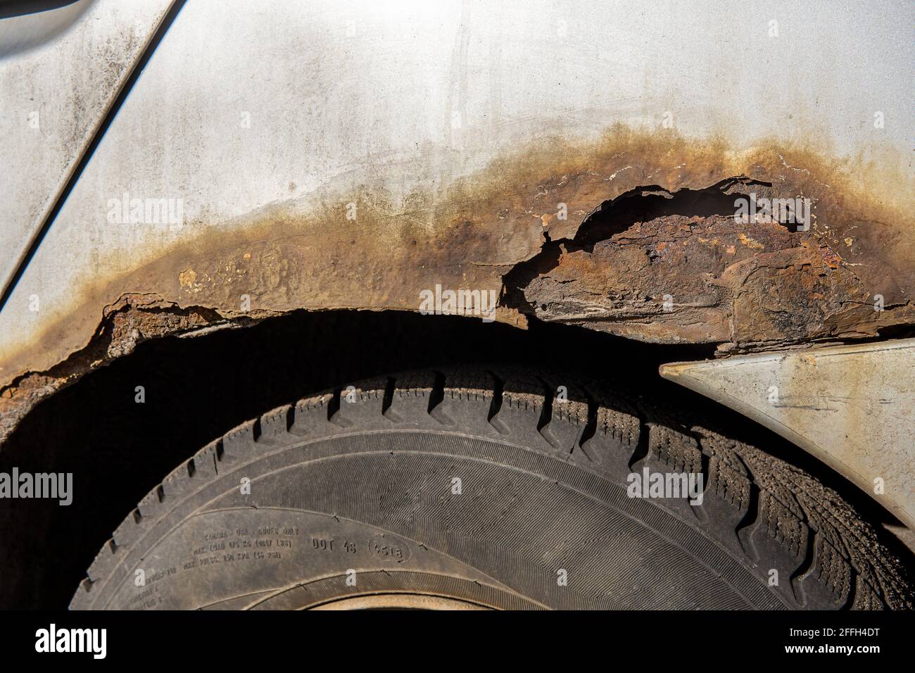 Sheet metal corrosion over wheel of old white car. Rusty messy surface ...