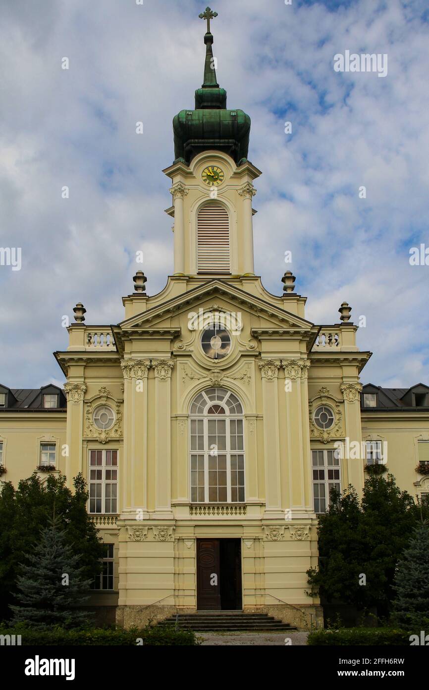 Facade of a catholic temple with a tower clock against a cloudy sky ...