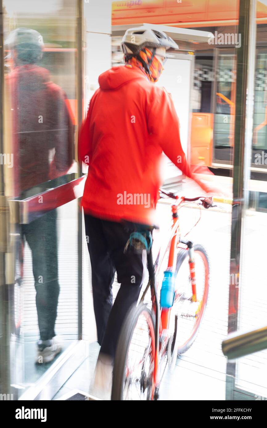 Selective focus of a cyclist riding out the door of his house with a ...