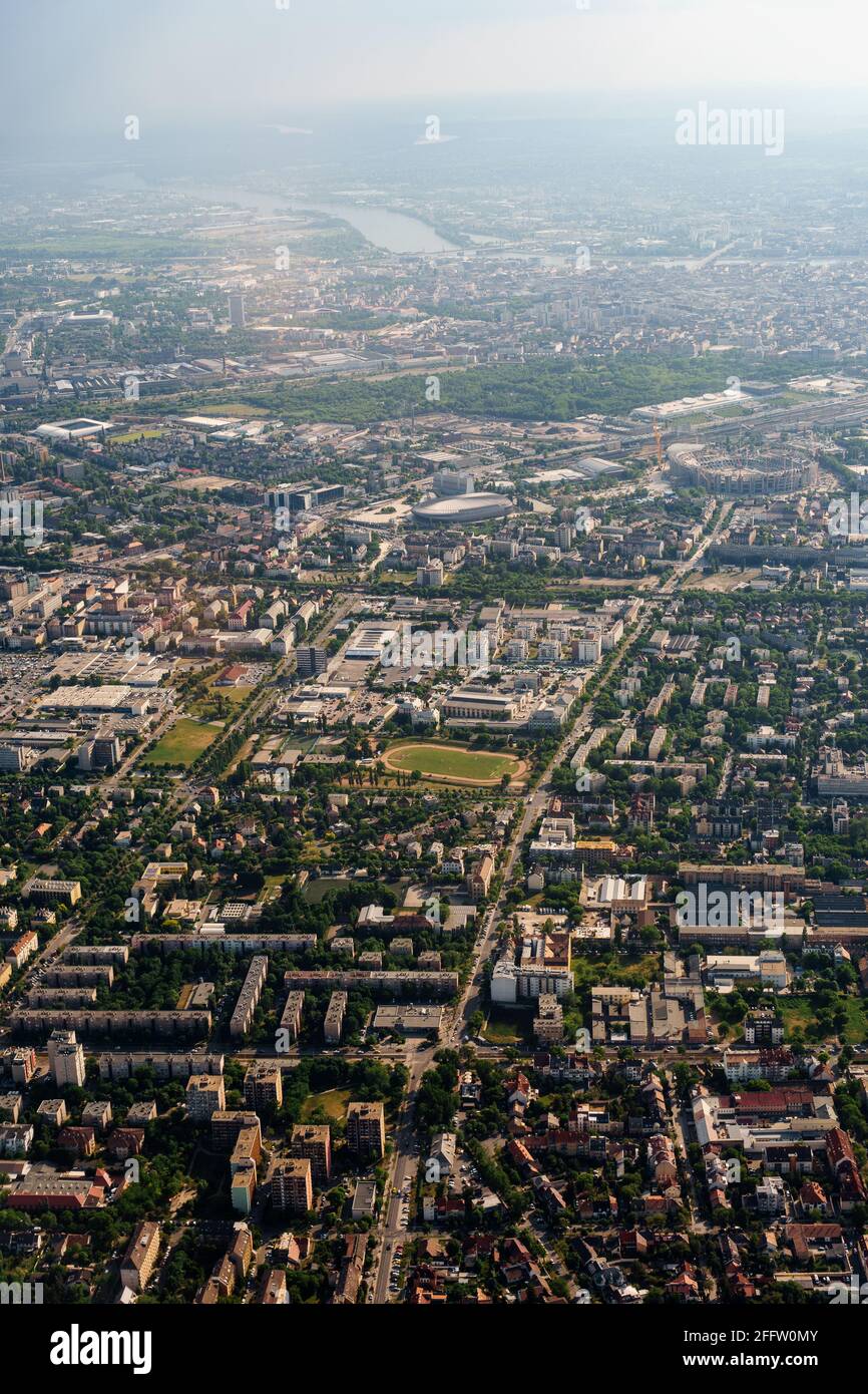 Airplane window view of modern houses surrounded by greenery and a ...